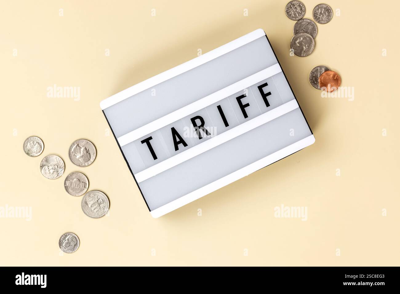 Coins arranged around a lightbox displaying the word tariff. Impact of ...