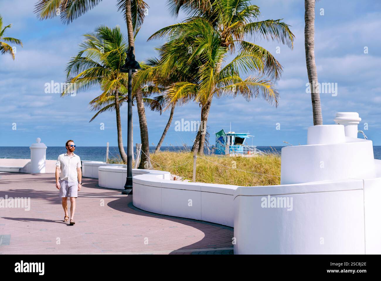 A beachfront scene in Fort Lauderdale with a man walking along a ...