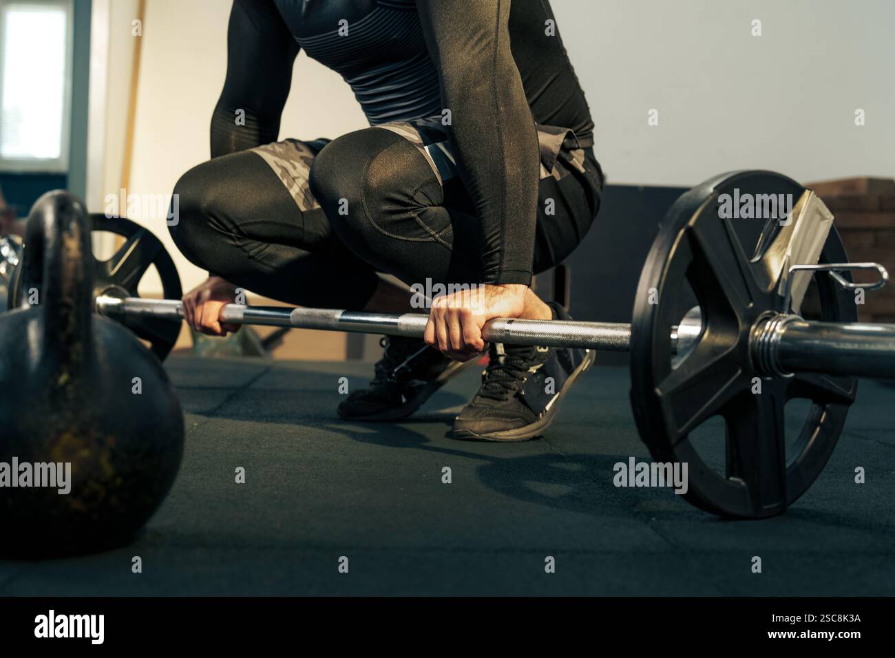 Strong individual preparing for a deadlift in a gym during early ...