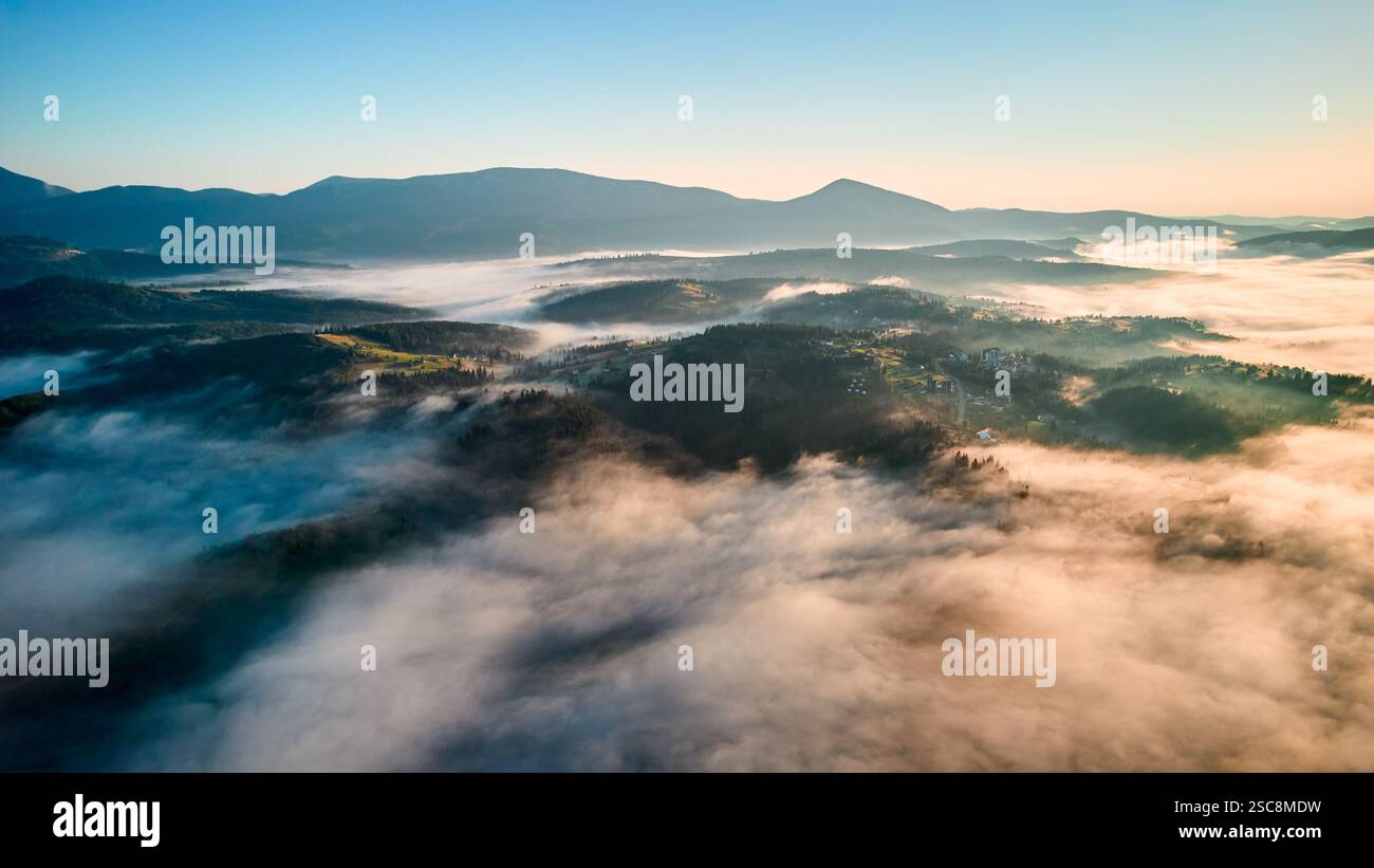 Aerial view reveals misty morning landscape with rolling hills and ...