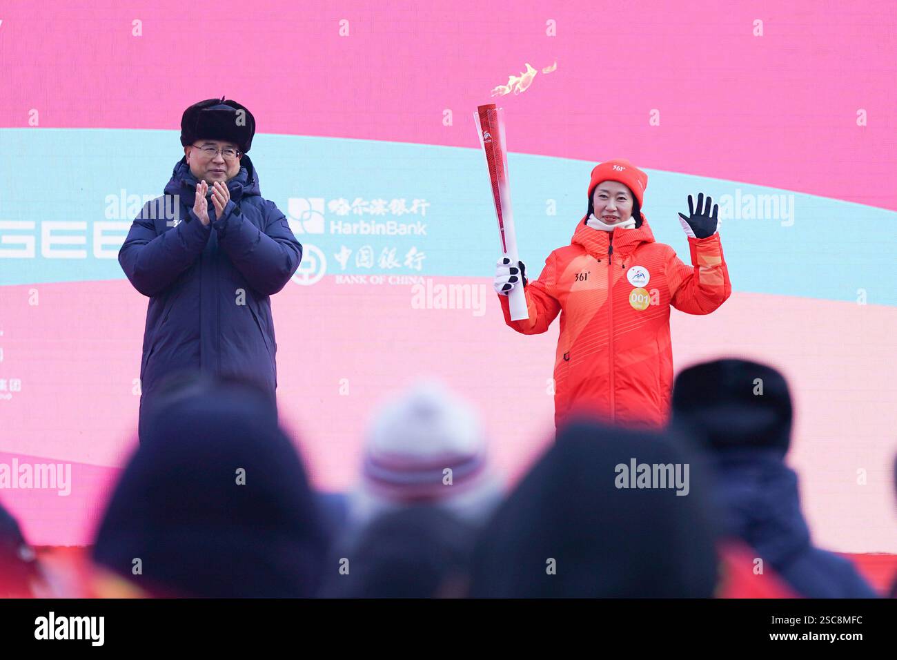 The first torchbearer, former figure skating world champion Shen Xue (R ...