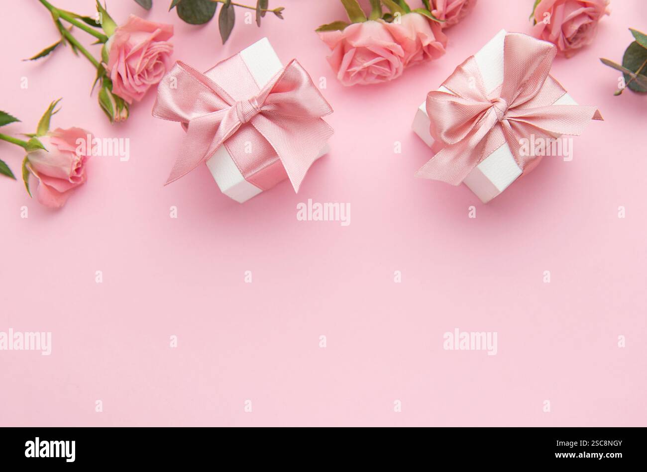 Valentine's day creative layout with pink roses and gift boxes on pink ...