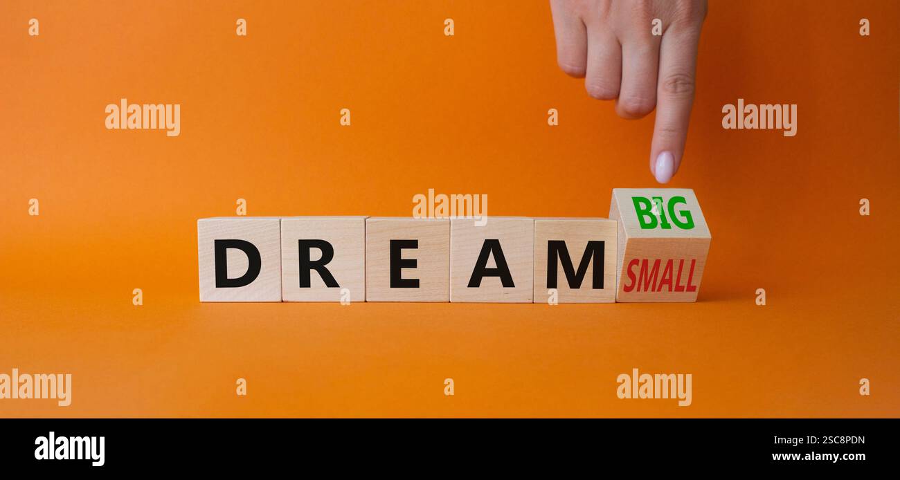 Dream Big vs Small symbol. Businessman Hand points at wooden cubes with ...
