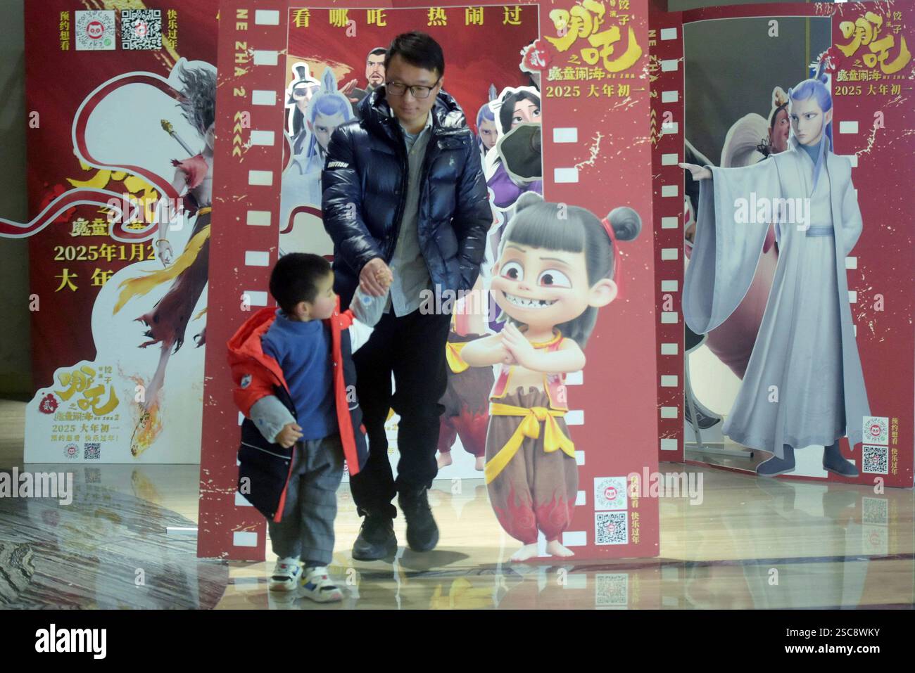 A man walks with his son through the posters for the animated movie Ne ...