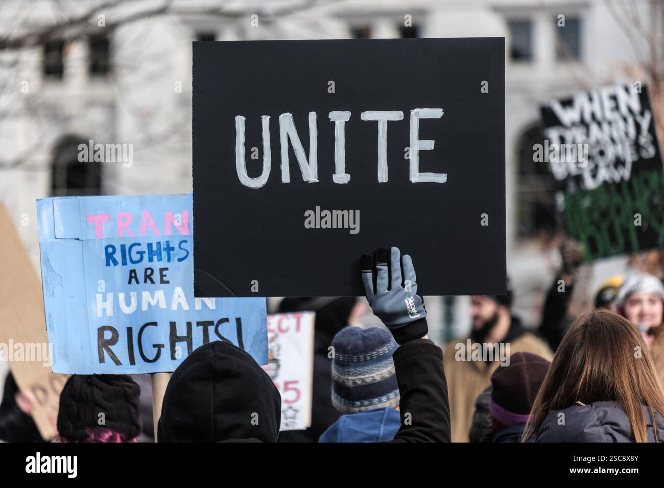 Protestors hold up signs protesting the policys of President Donald ...