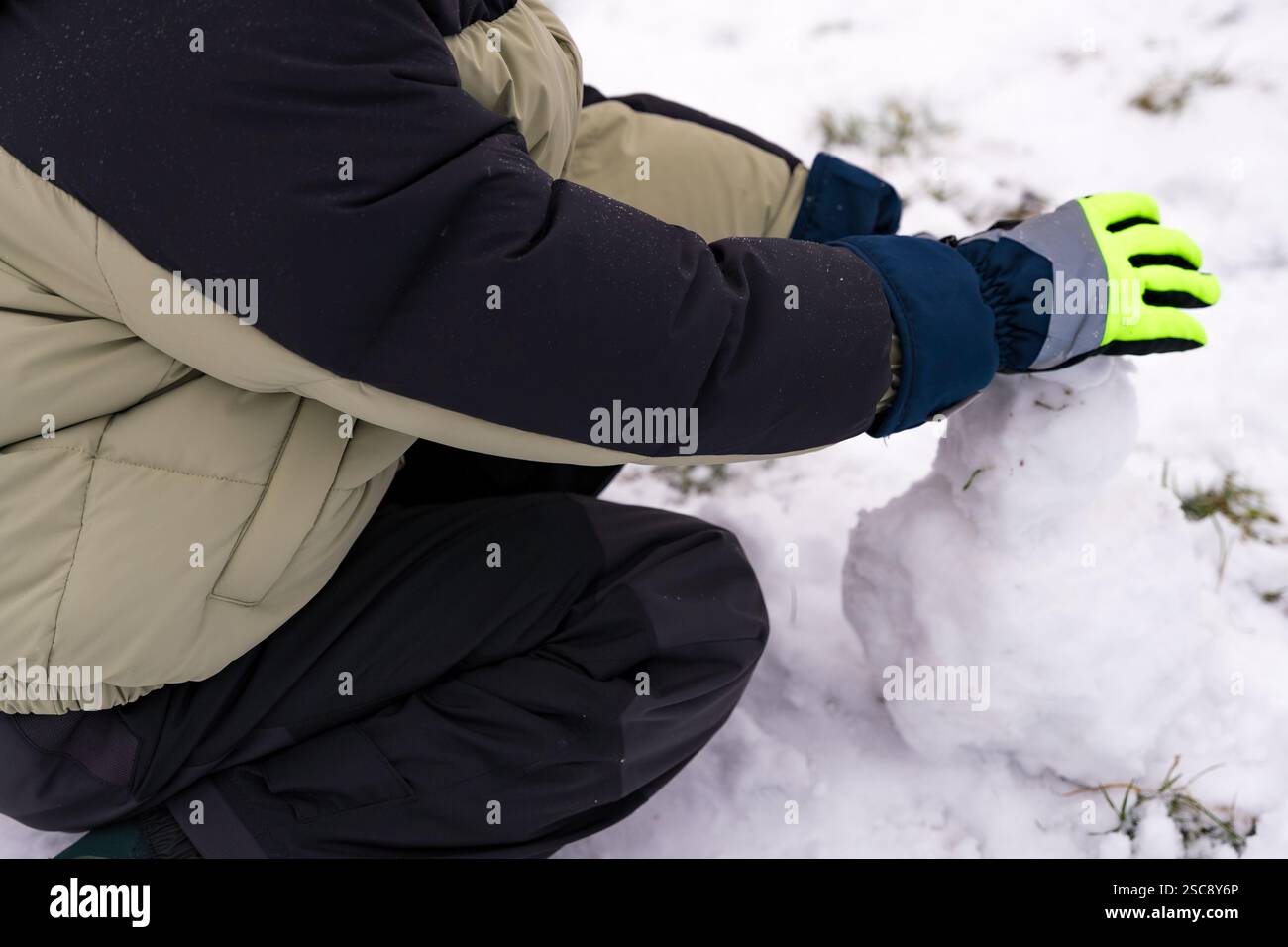 Child building a small snowman in winter outdoor fun Stock Photo - Alamy