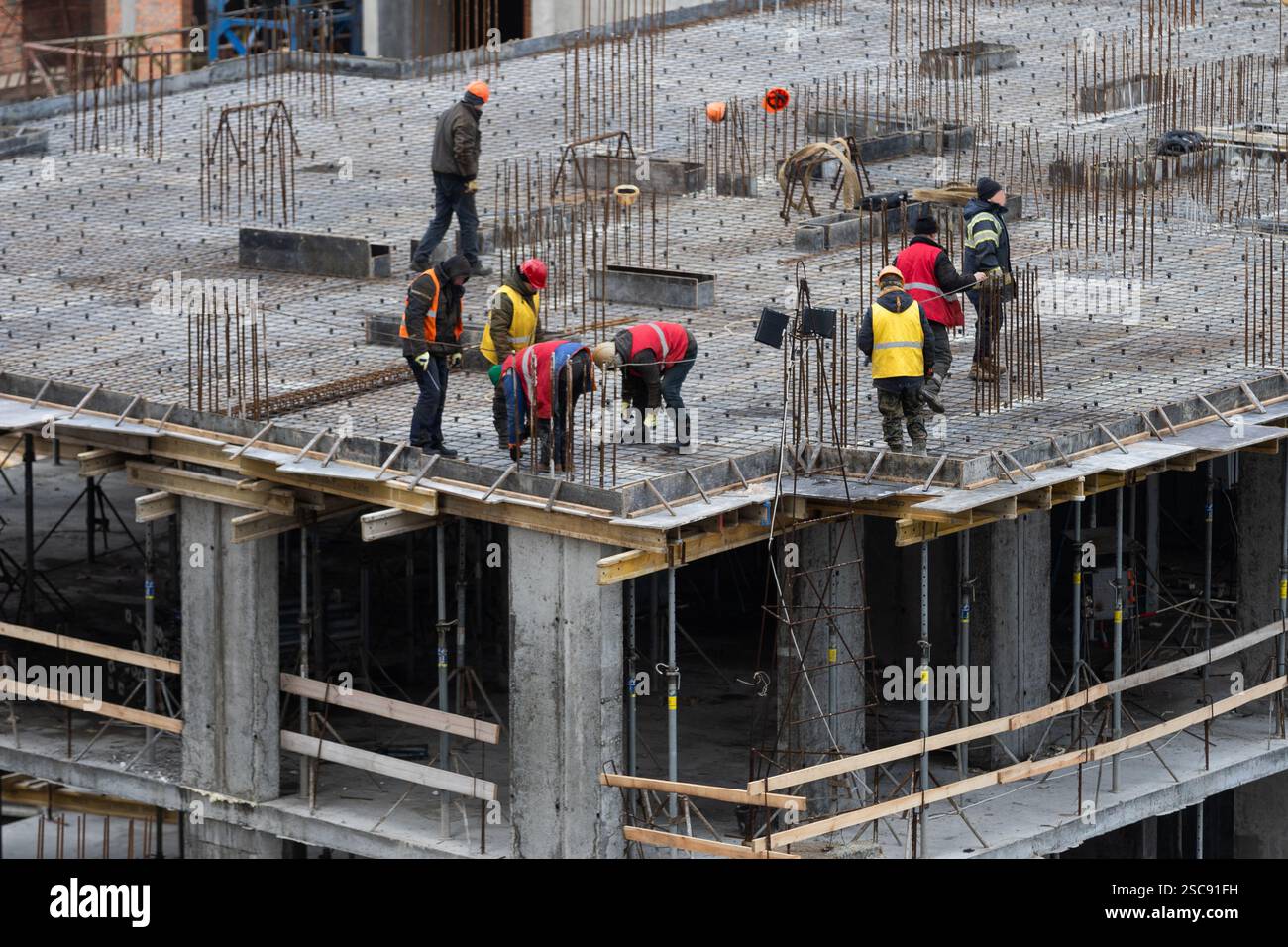 concreting work: construction site worker during concrete pouring into ...