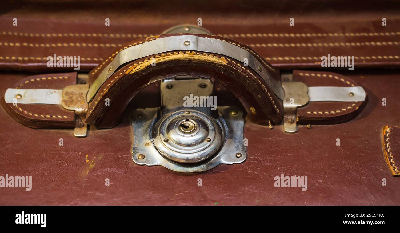 Front view of vintage worn-out leather suitcase with three metallic ...