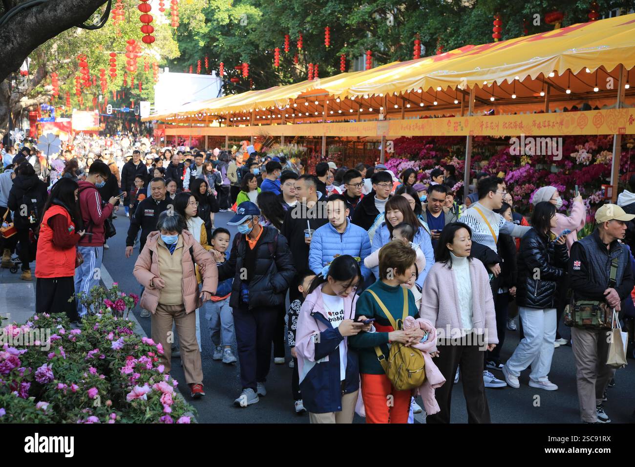 Tourists stroll in the flower street in Guangzhou City, south China's ...