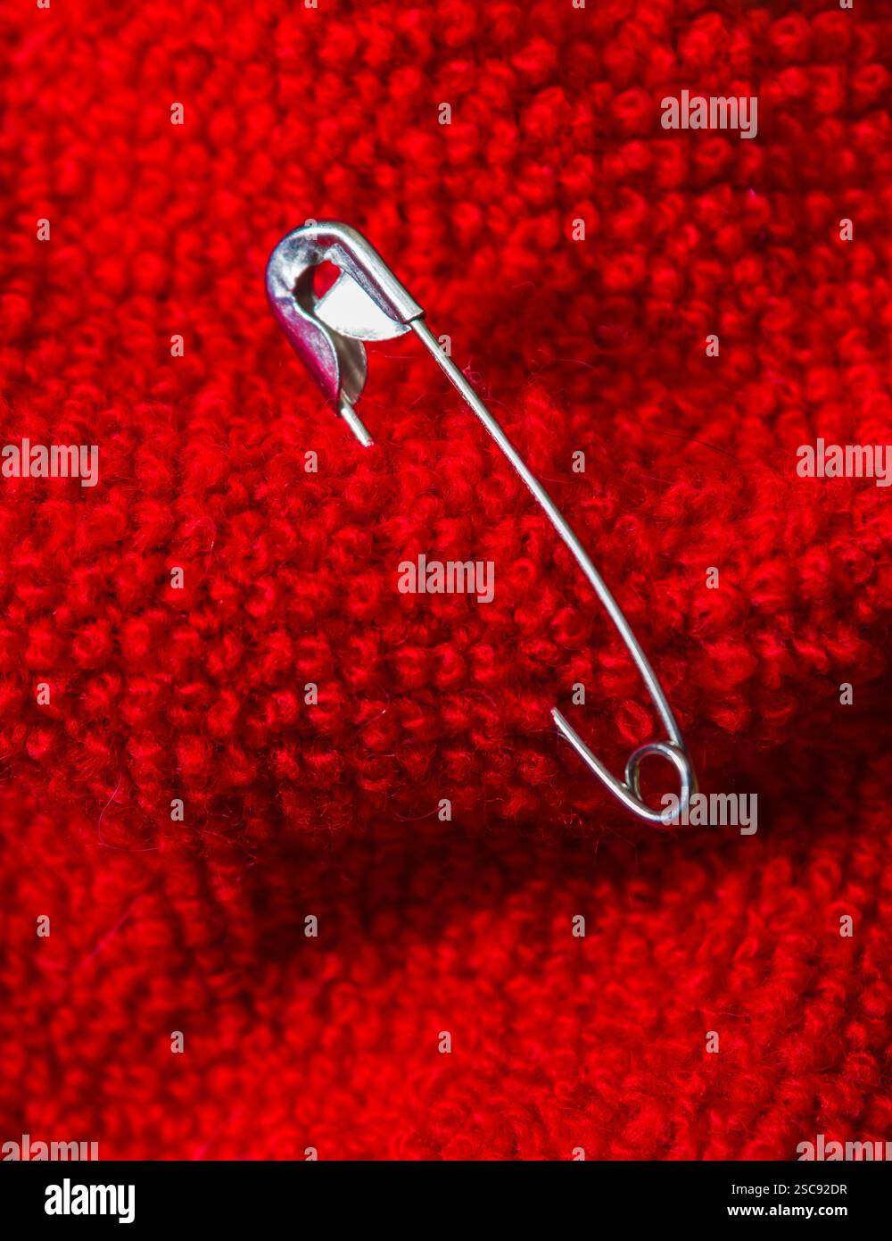 Safety pin pinned to the texture color fabric Stock Photo - Alamy