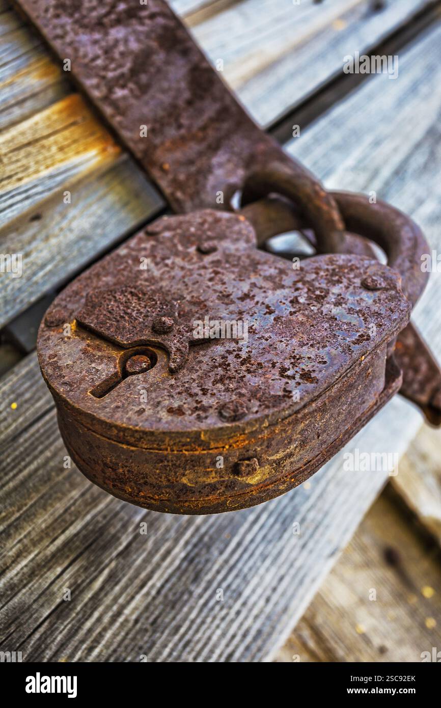 Old latch with padlock on gatees Stock Photo - Alamy