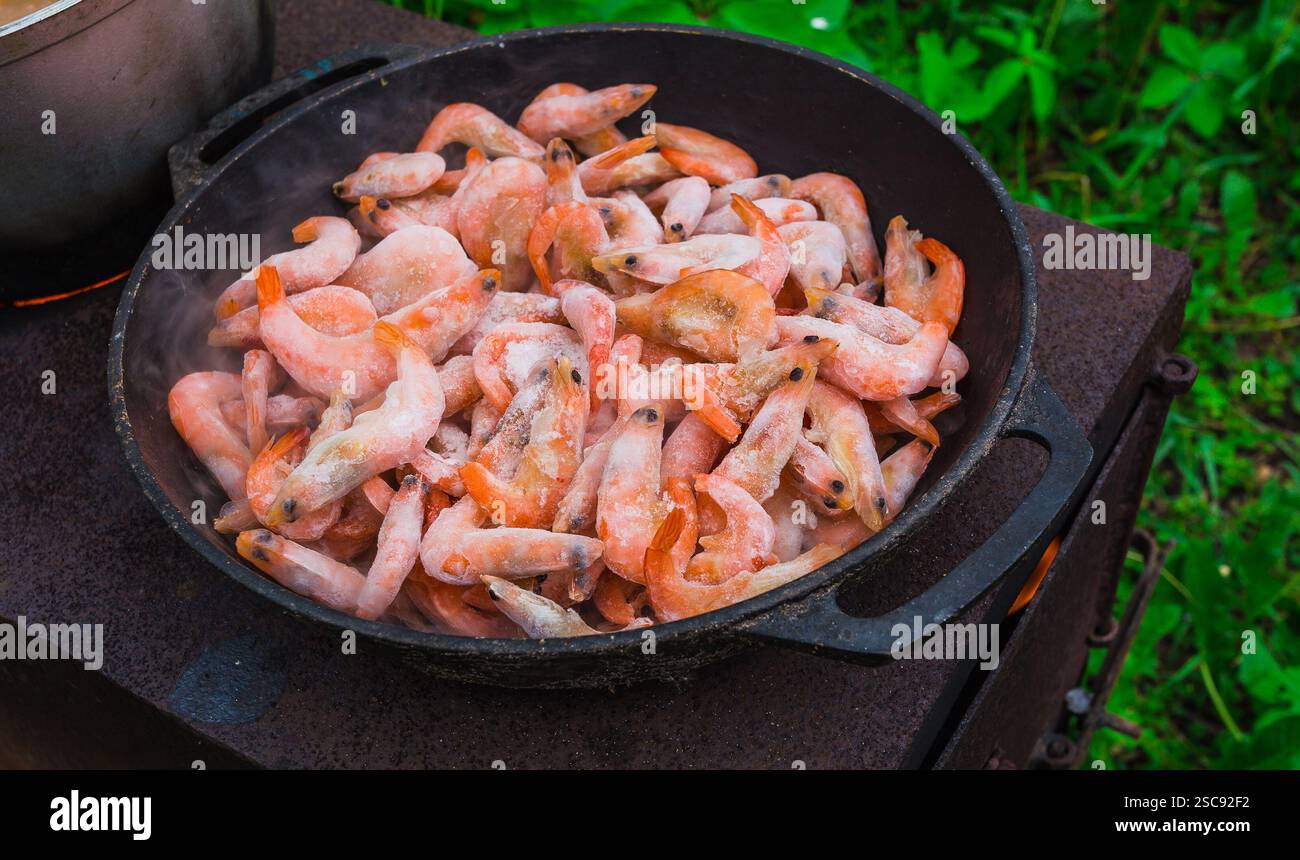 Cooking frozen shrimp in an old frying pan Stock Photo - Alamy