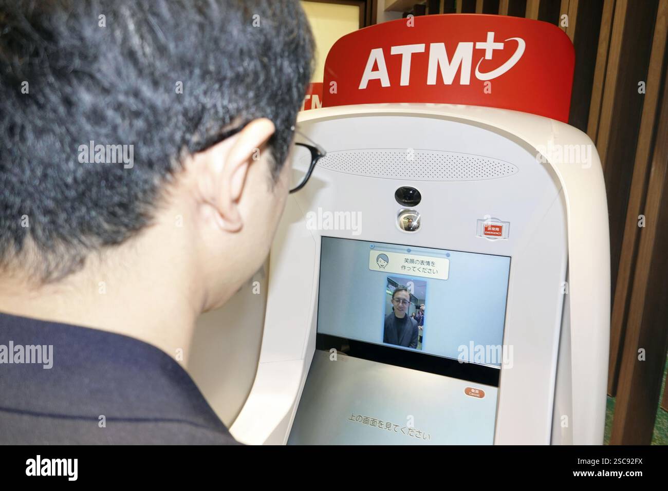 A man uses a Seven Bank ATM machine in Tokyo on Feb. 6, 2025, via a facial recognition system ...