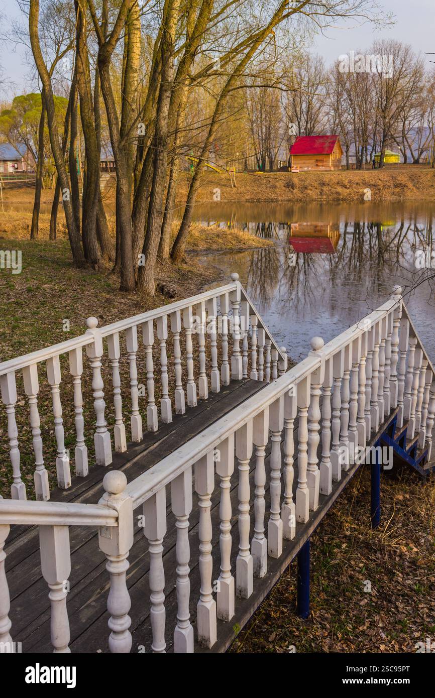 railing with balusters on the background of a wooden cottage with a red ...