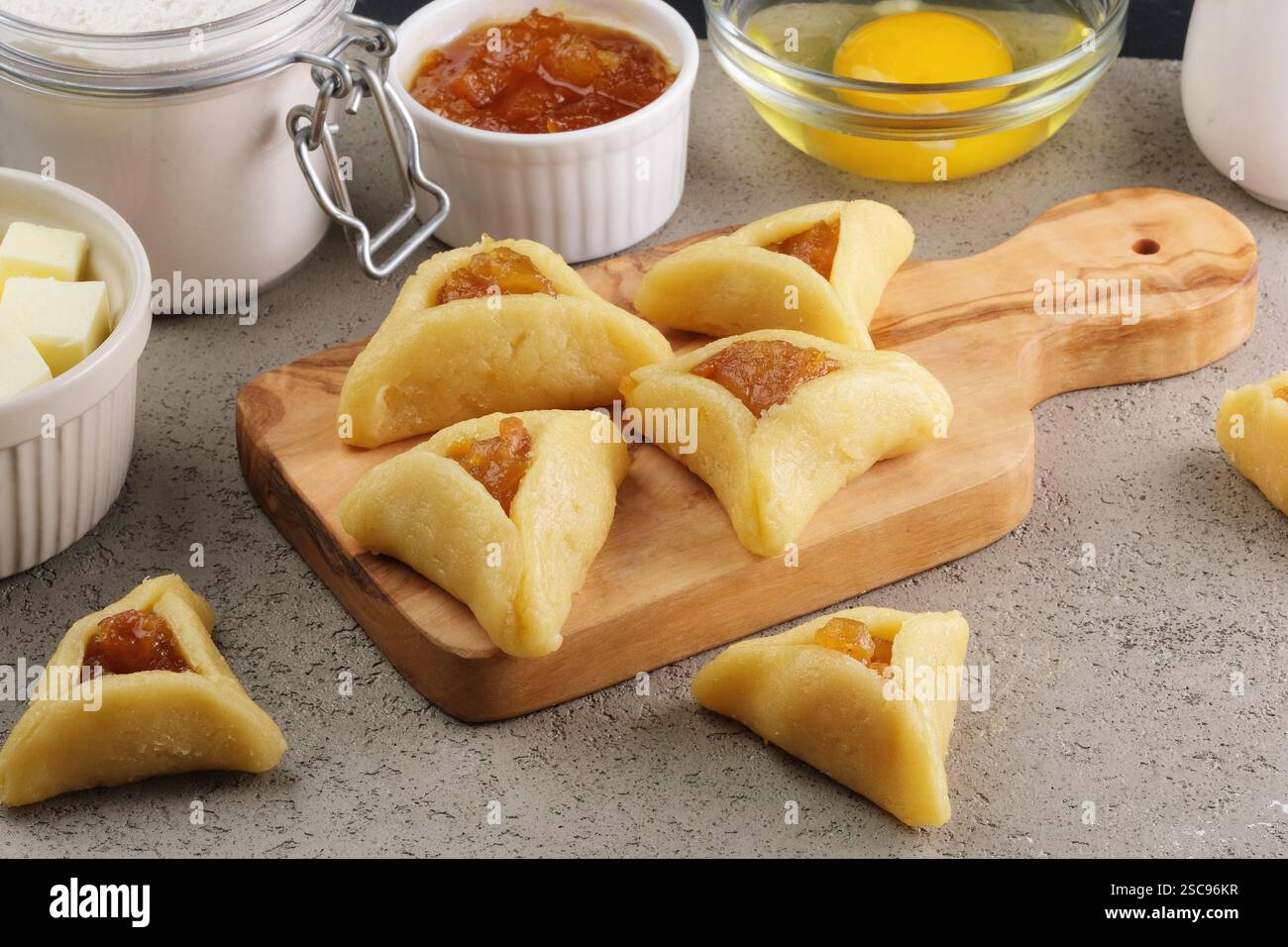 Raw sugar cookies in a triangular shape with filling on a wooden ...