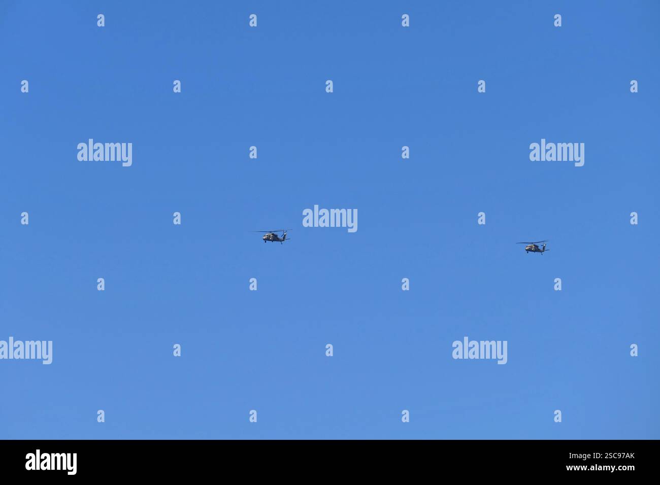 Military helicopters flying in the blue sky. Two helicopters flying in ...