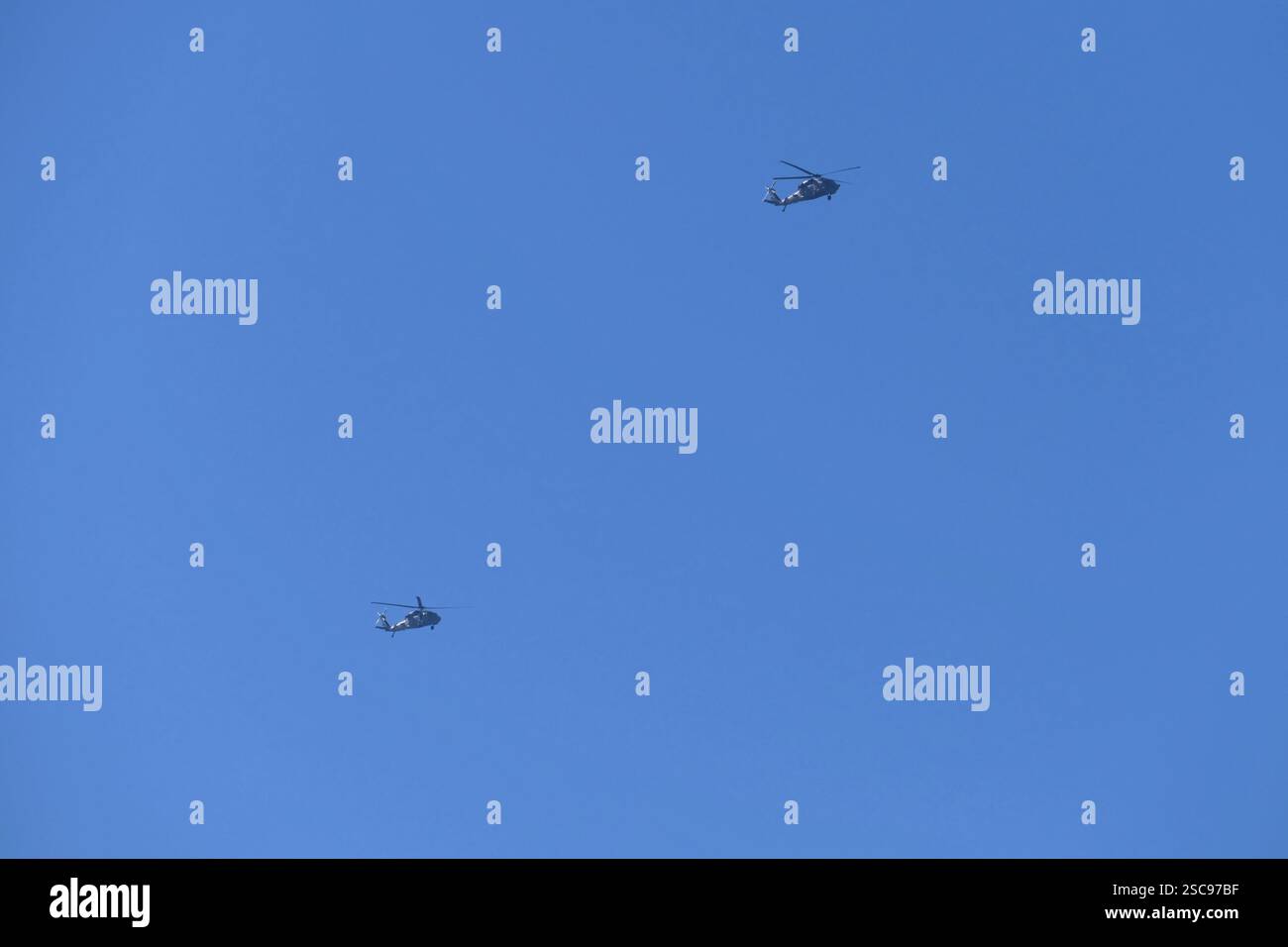 Military helicopters flying in the blue sky. Two helicopters flying in ...