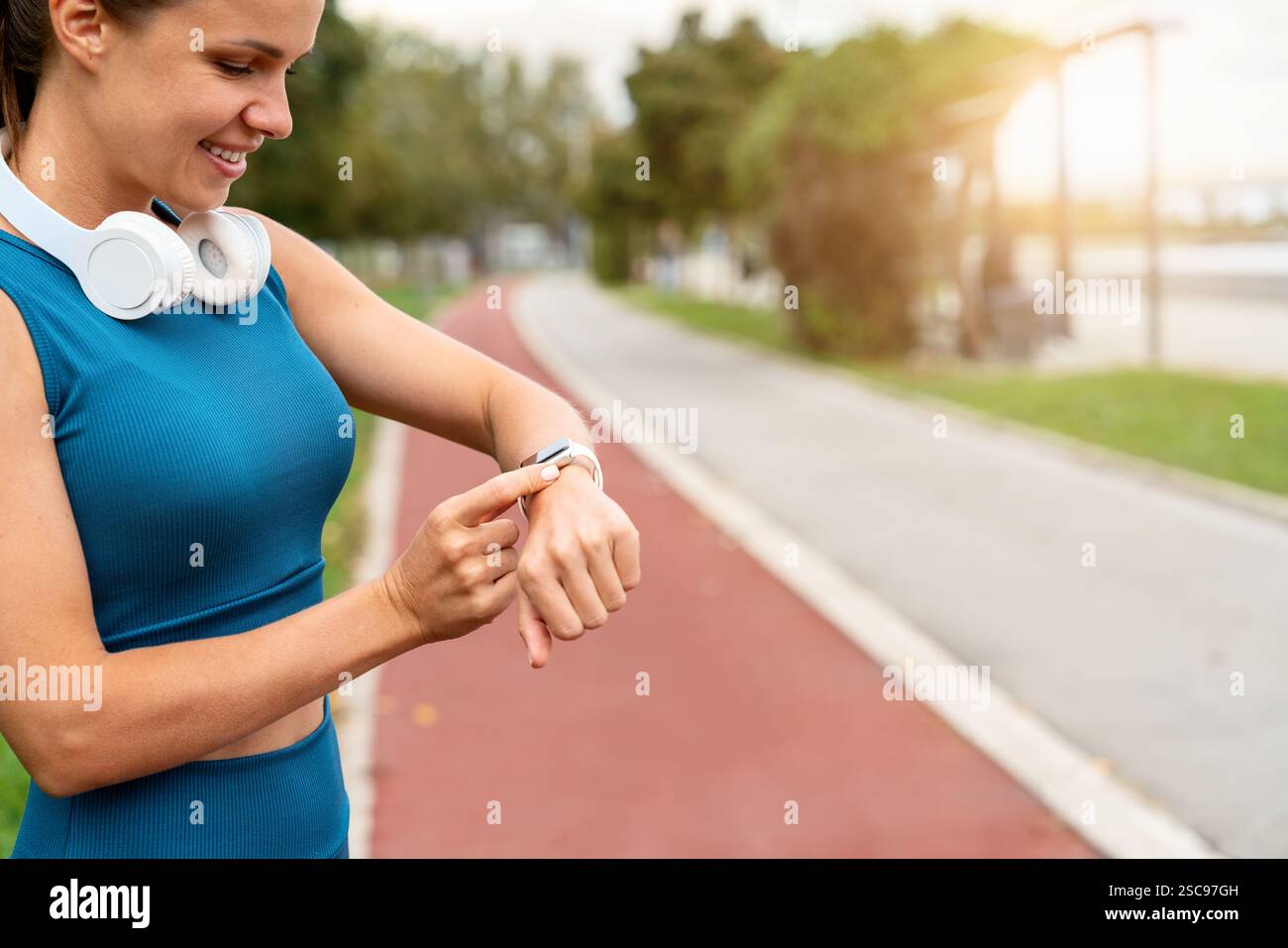 Female athlete runner using wearable fitness tracker outdoors on ...