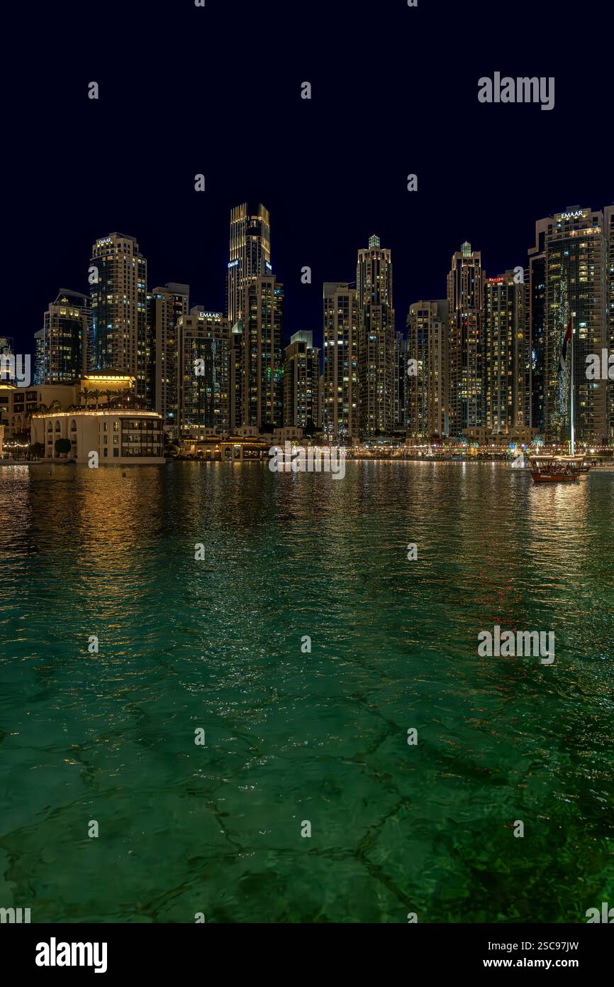 Evening at Burj Khalifa Lake in Dubai. Surrounded by twinkling ...