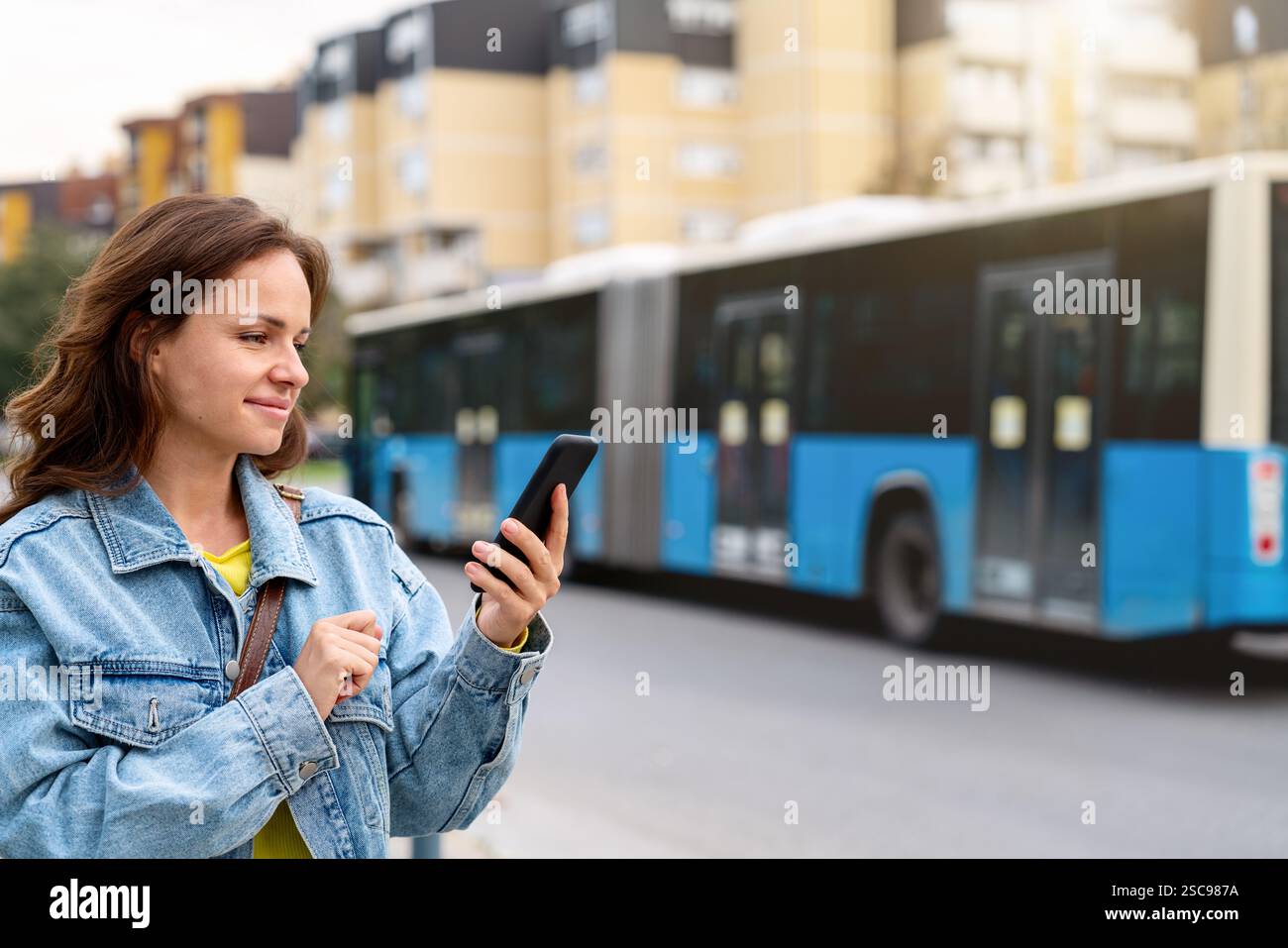 City public transport mobile app. Urban woman using her smart phone on ...