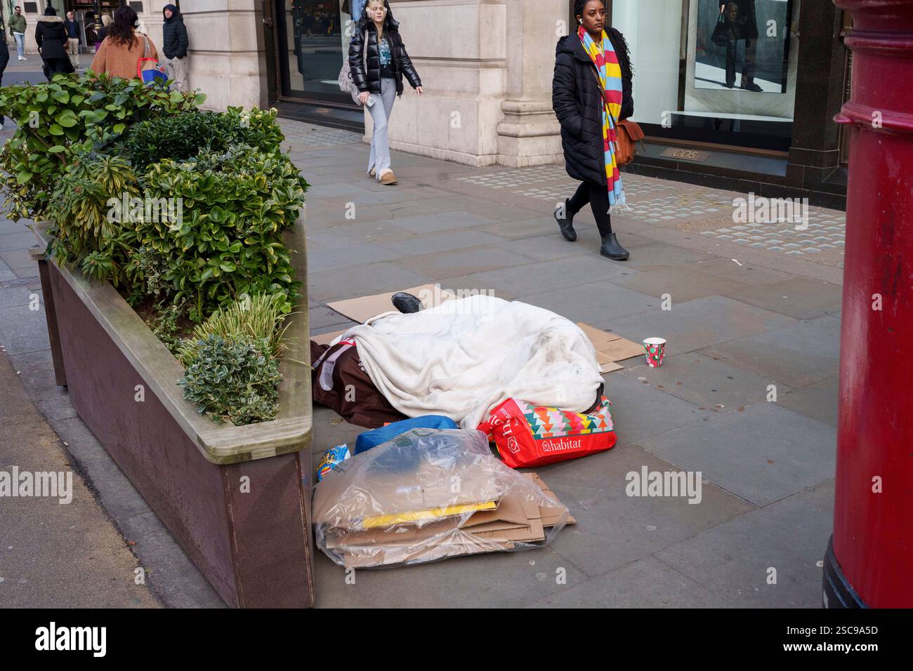 As West End shoppers walk-by, a rough sleeper is covered by a blanket ...