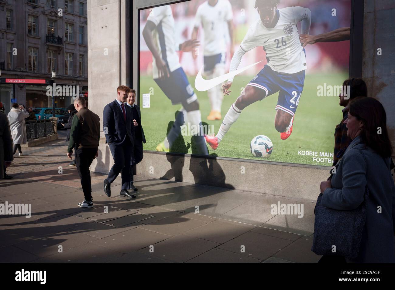 West End shoppers walk past a 'Just Do It' ad slogan that features ...