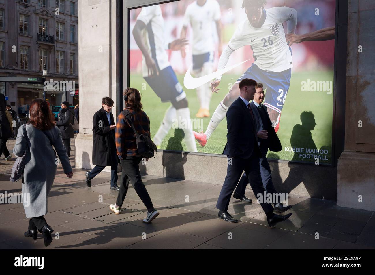 West End shoppers walk past a 'Just Do It' ad slogan that features ...