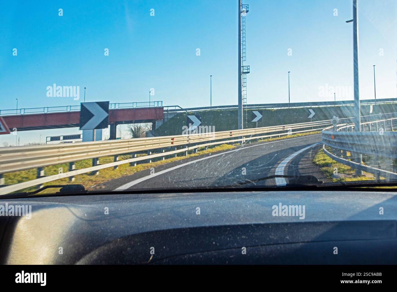 sharp turn of a toll road through a dirty windshield. Traveling by car ...