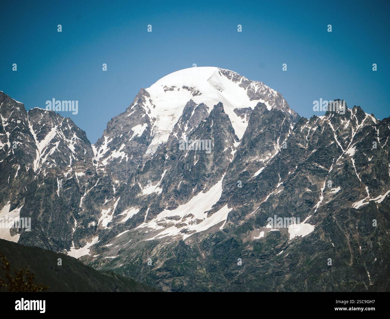 Snow-dusted summits rising above lush forested hills, highlighting ...