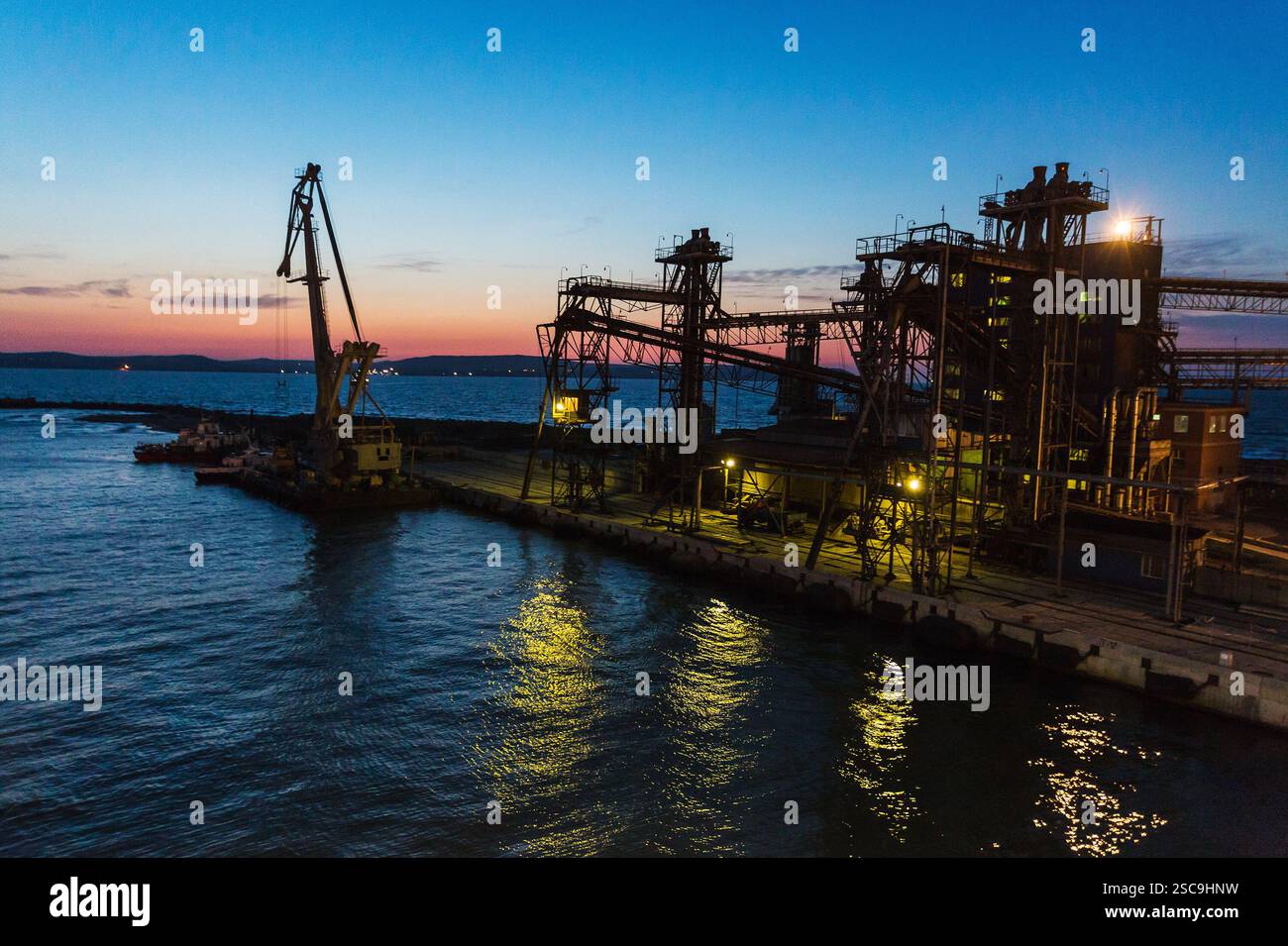 Panorama image of the illuminated cargo port in Crimea at night with ...