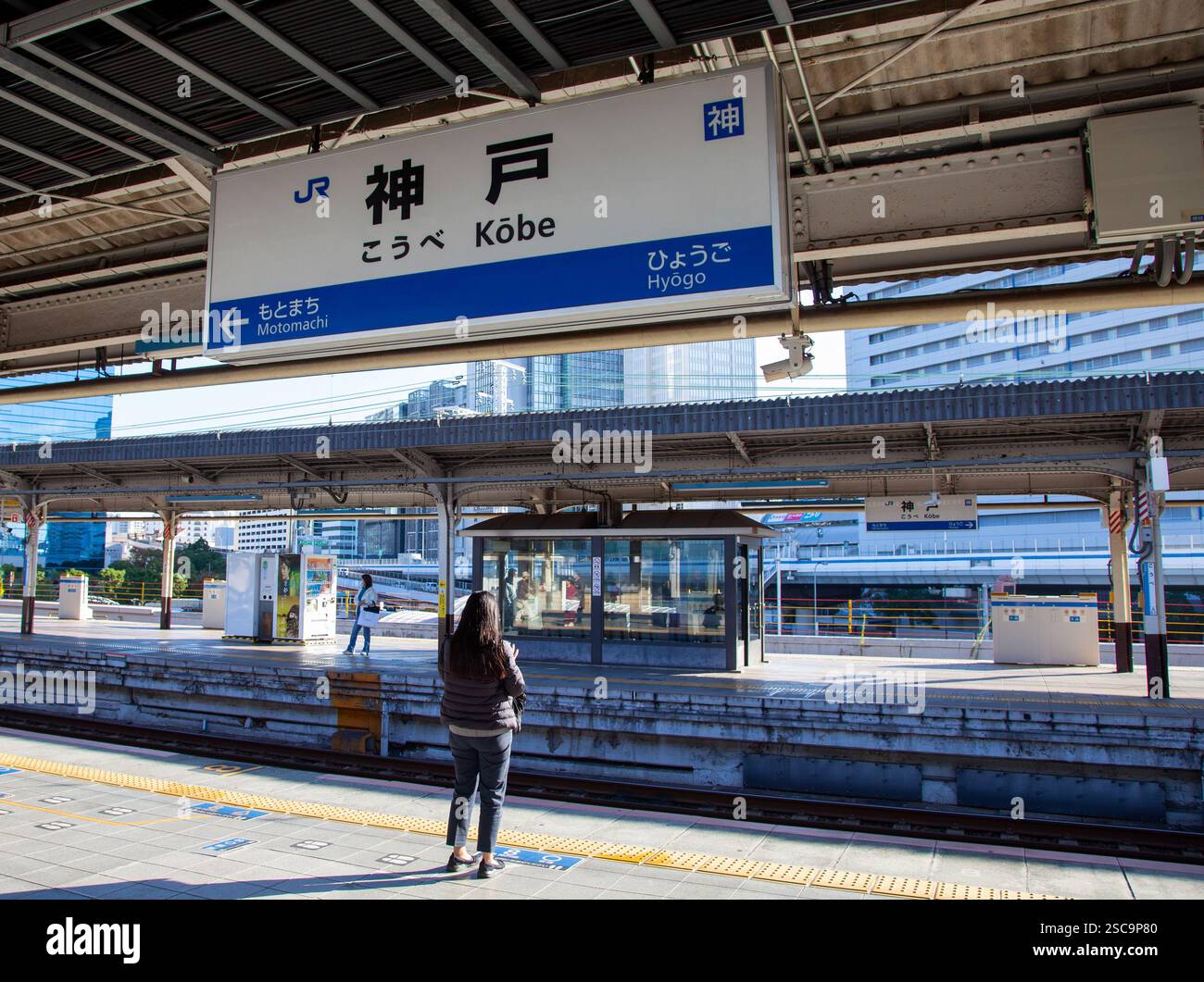 Kobe Station platform with people waiting on the platform for a train ...