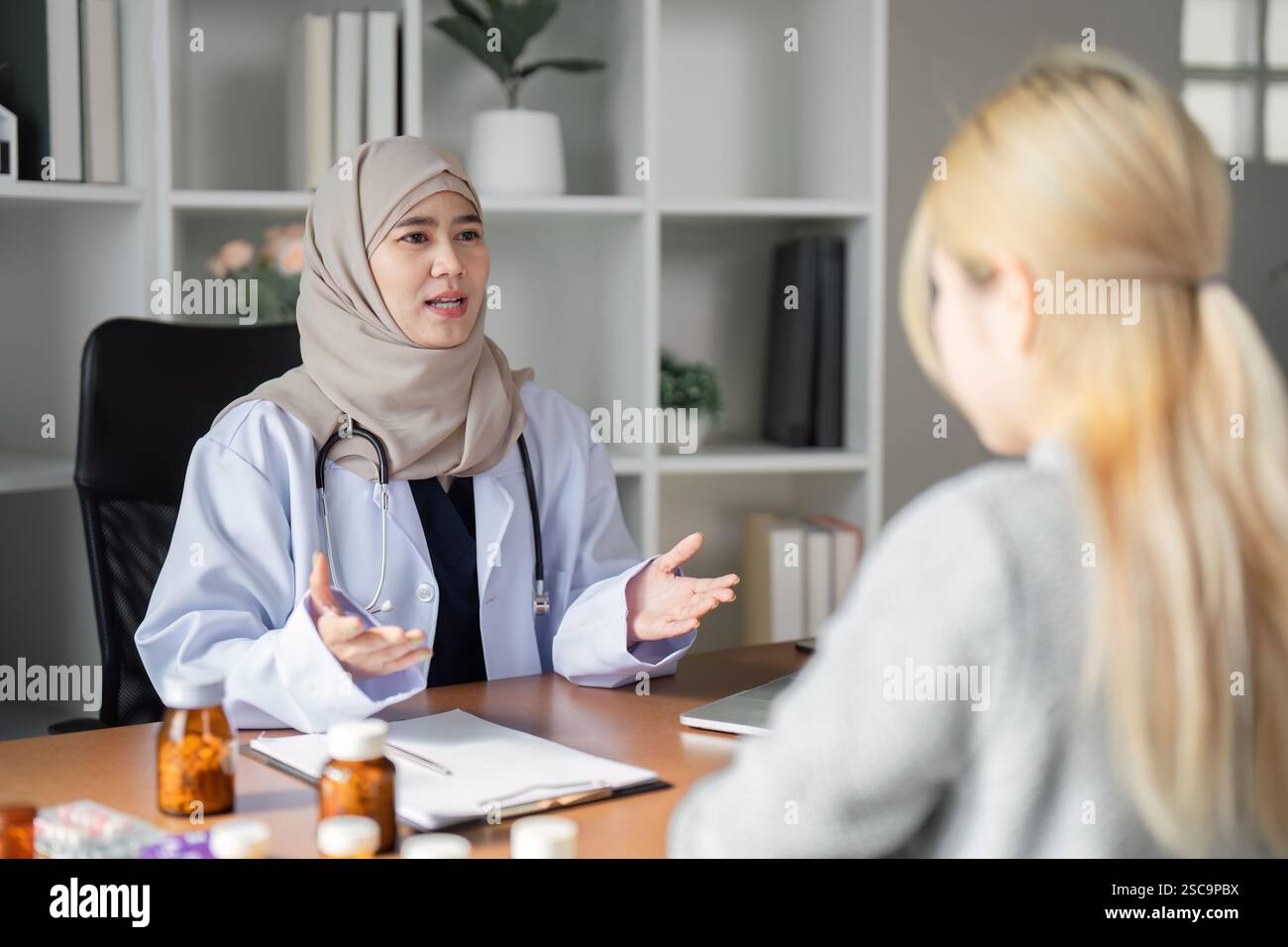Engaged Muslim female doctor explaining treatment options to a patient ...