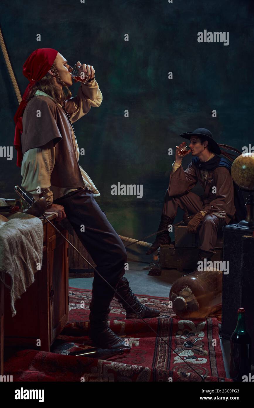 Two men, dressed like medieval prated raising glasses with rum ...