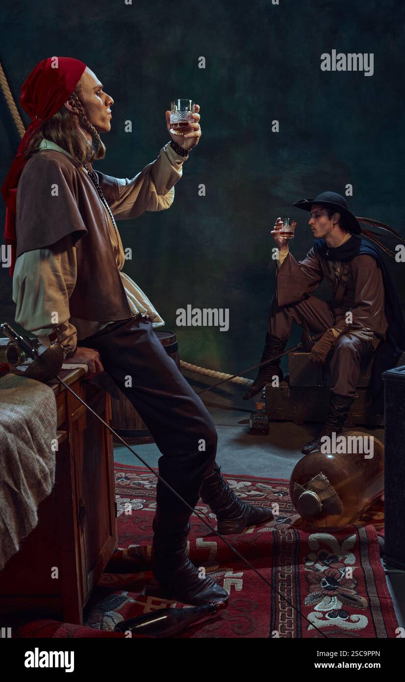 Two men, dressed like medieval prated raising glasses with rum ...