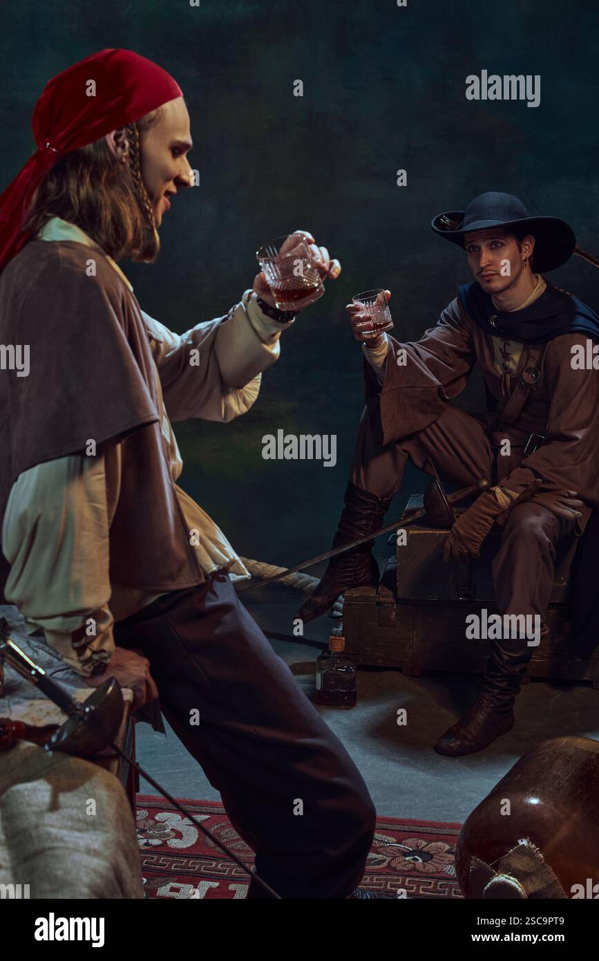 Two men, dressed like medieval prated raising glasses with rum ...