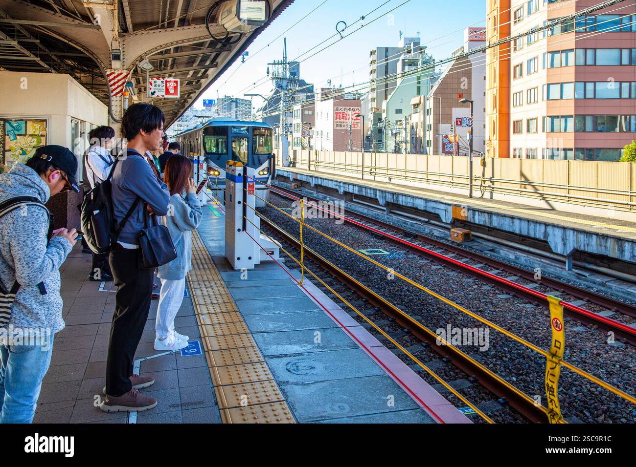 Kobe Station platform with people waiting for the train to Osaka in ...