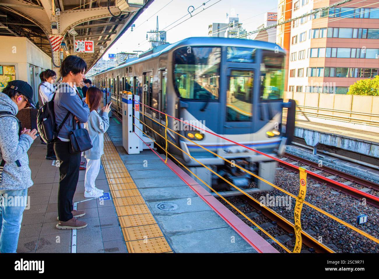 Kobe Station platform with people waiting for the train to Osaka in ...