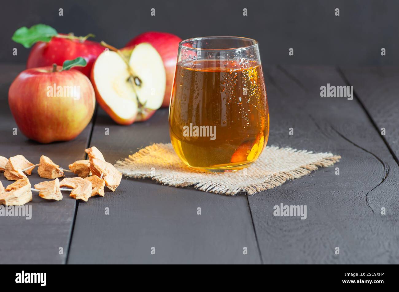 Fresh organic apple juice in glass cup with ripe red and dried apples ...