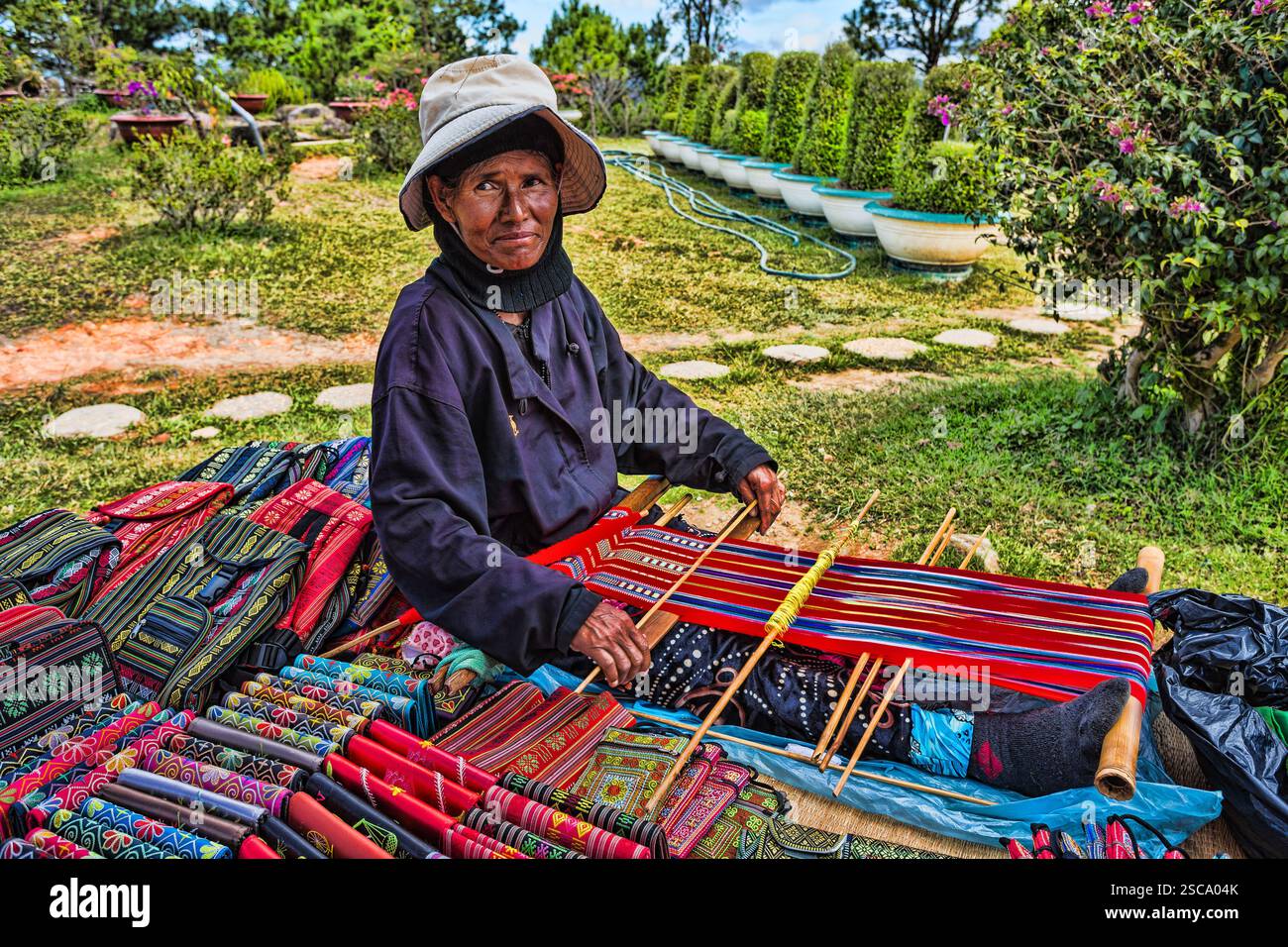 Vietnam, 26 NOV, 2014. A woman weaves fabric with national patterns ...