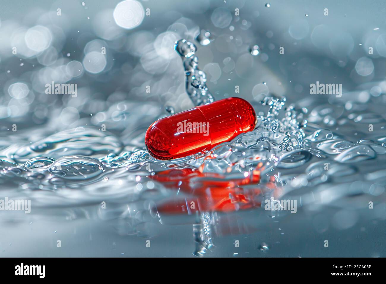 A red pill capsule is floating in a pool of water with water splashes, surrounded by bubbles ...