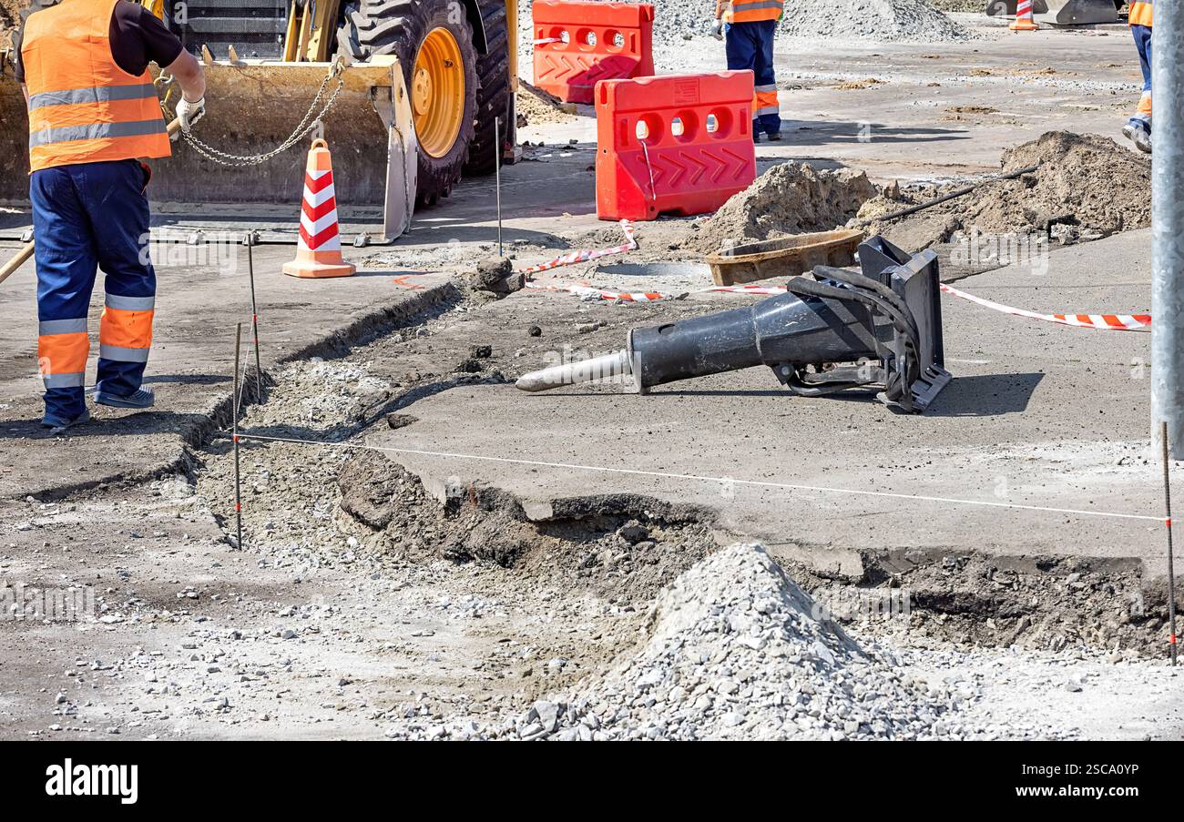 Construction workers actively repairing roads and using heavy machinery ...