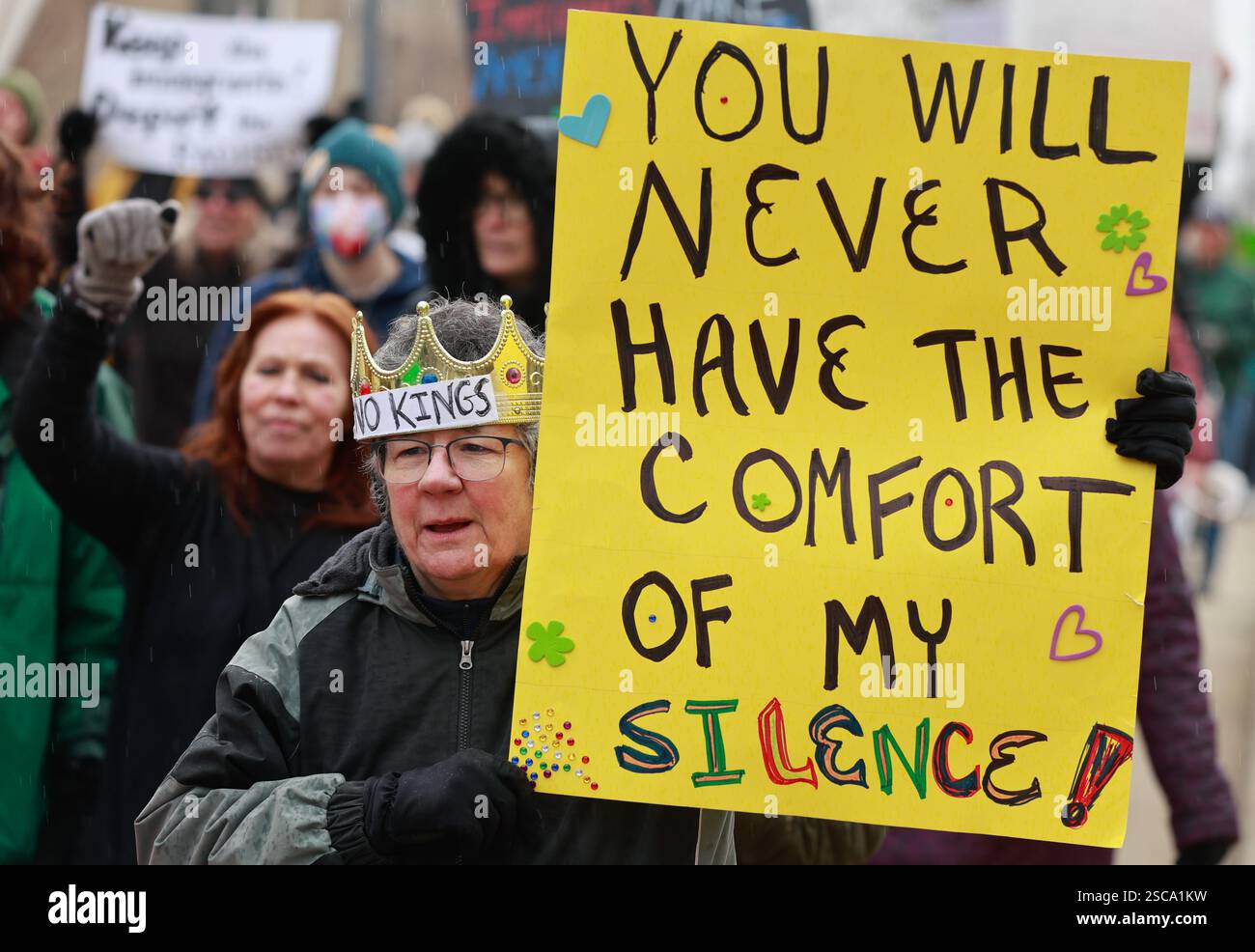 A demonstrator wearing a crown holds a sign that reads, “You will never ...
