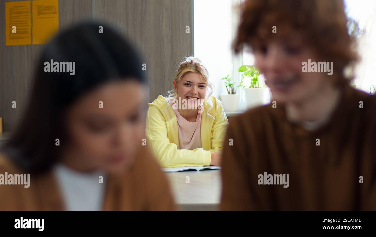 Three school mates students pupils studying in class lesson blurry man ...