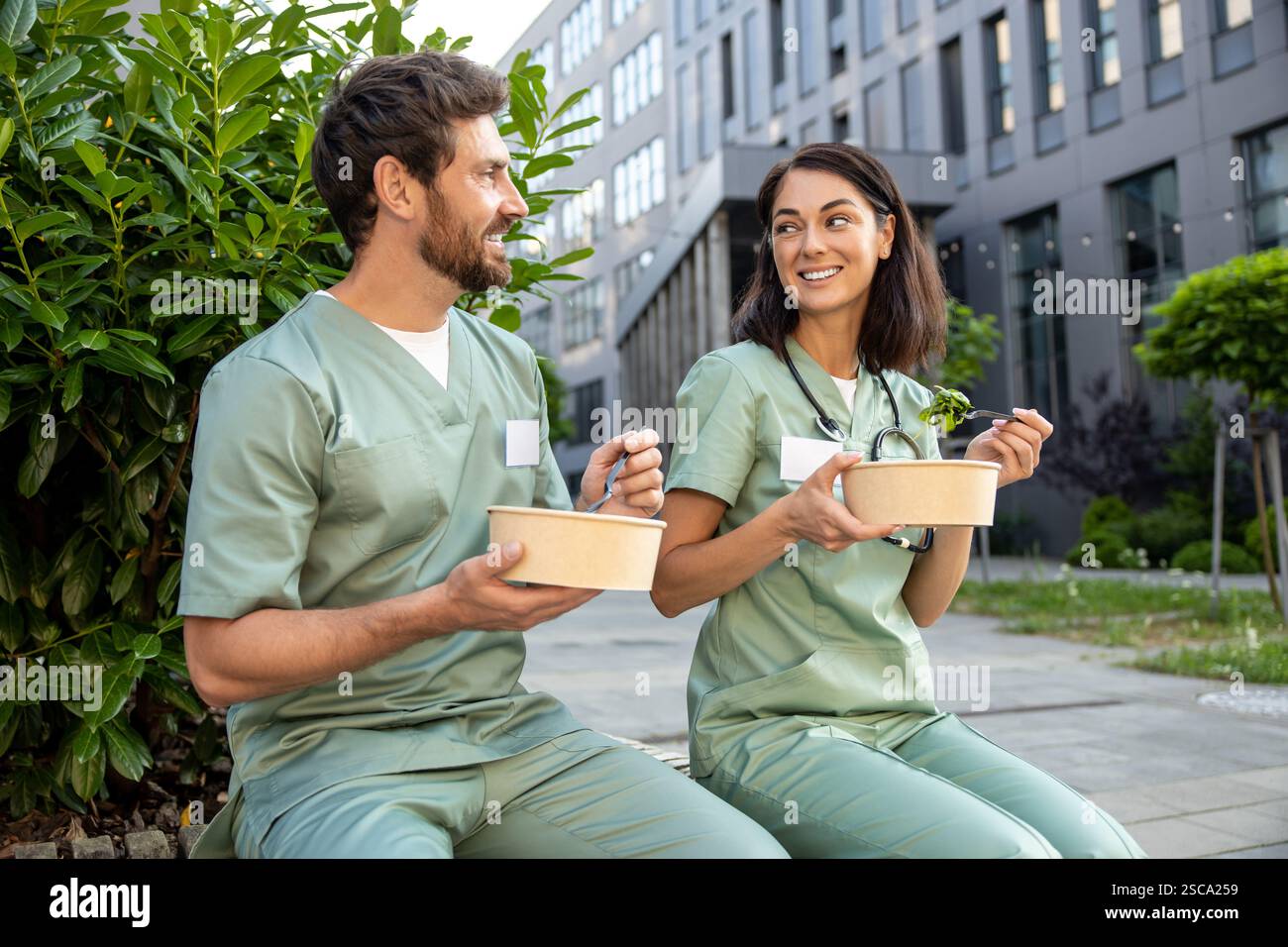 Two doctors having lunch together in the clinic yard Stock Photo - Alamy