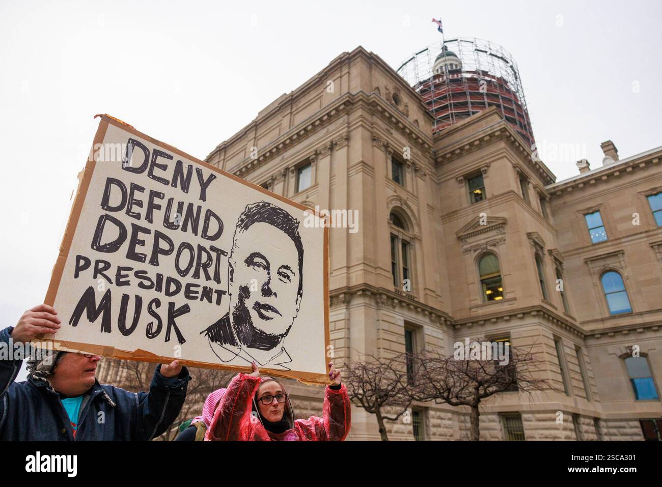 A demonstrator holds a sign that reads, “Deny Defund Deport President ...