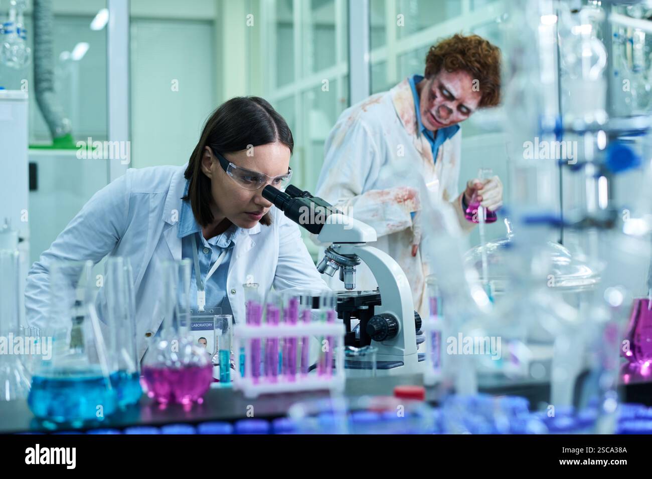 Female Researcher Using Microscope At Work In Lab Full Of Zombies Stock ...