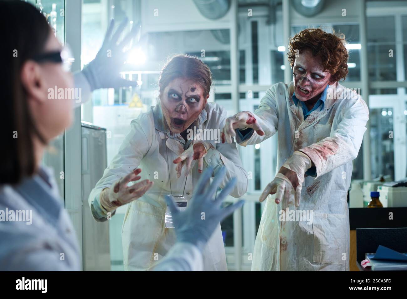 Young People In Zombie Costumes Playing Prank On Their Colleague Stock ...