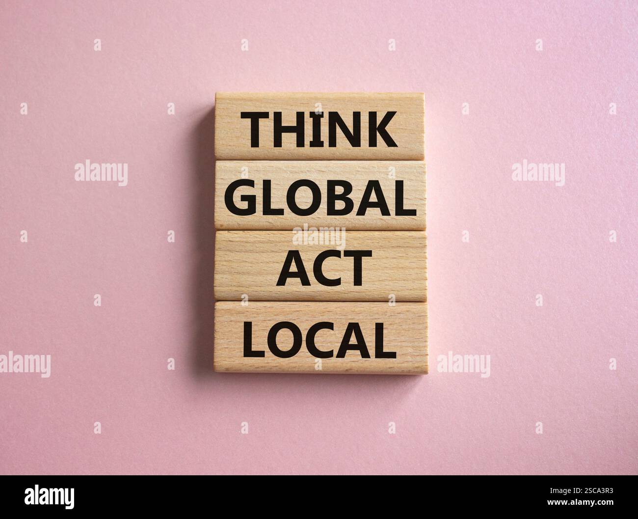 Think global act local symbol. Wooden blocks with words Think global act local. Beautiful pink ...