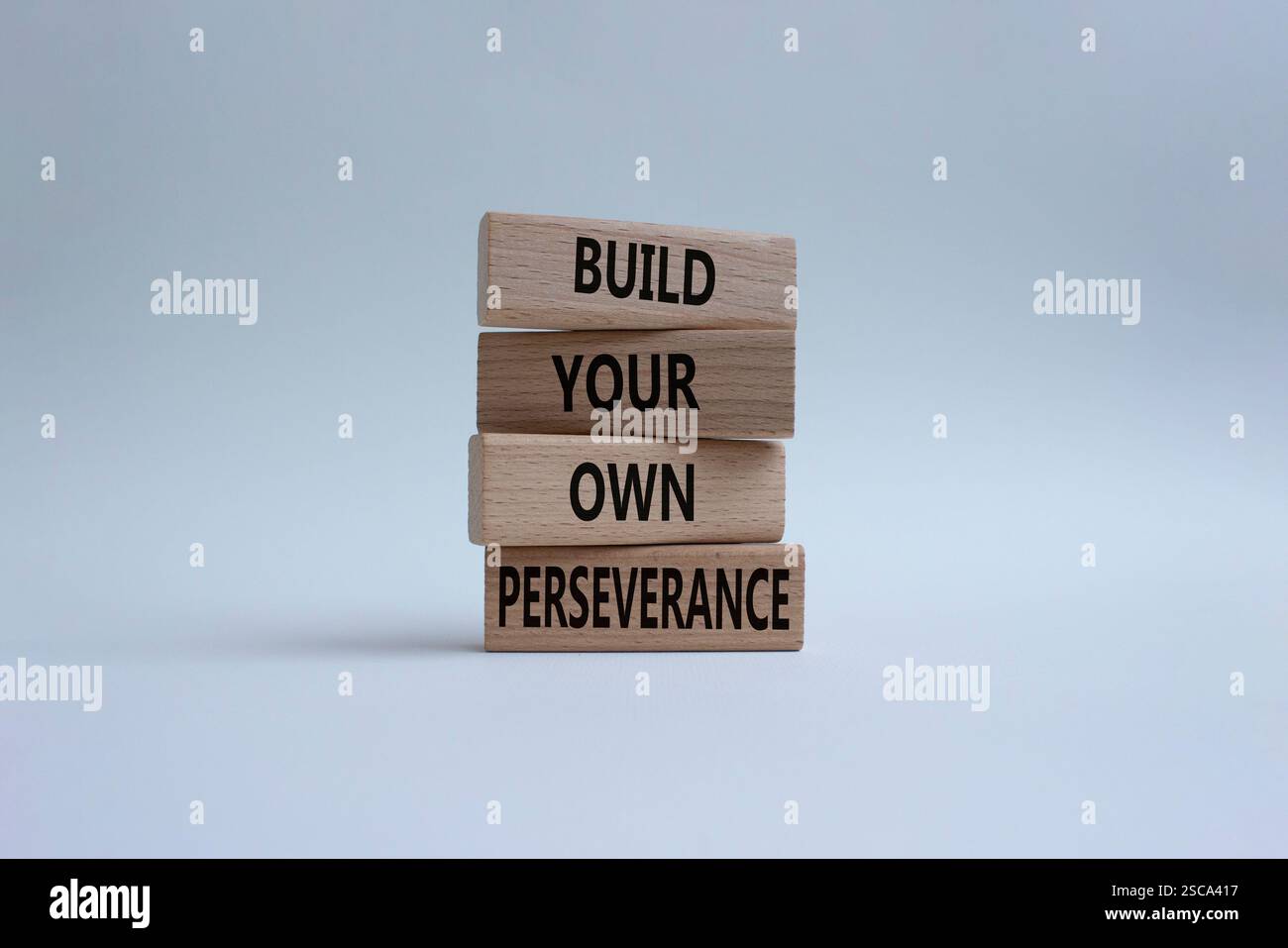Perseverance symbol. Wooden blocks with words 'Build your own ...