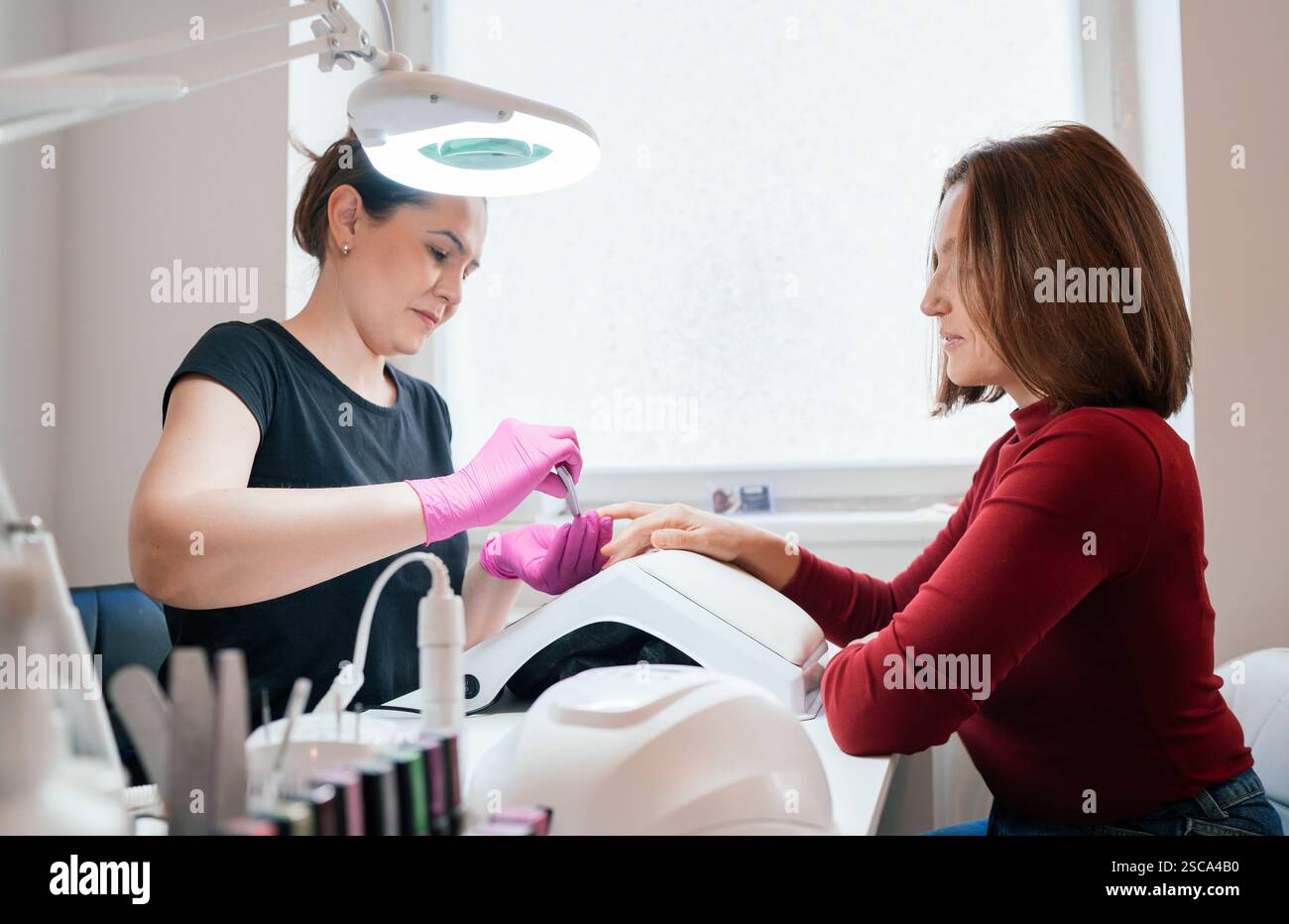 Manicure specialist shaping nails with precision using professional ...